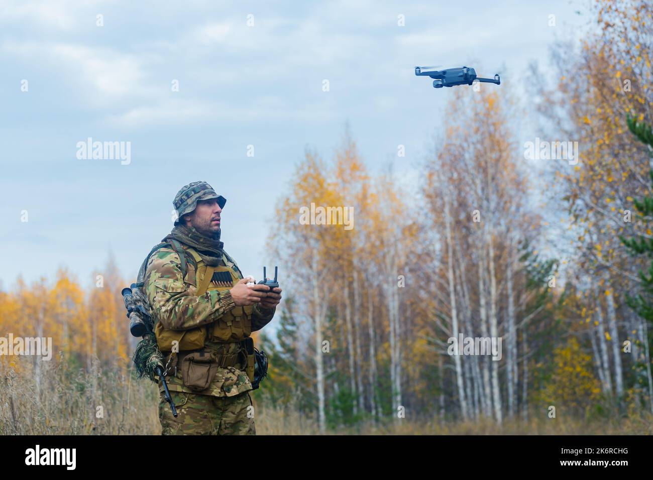 Mercenary soldier launch a reconnaissance drone in a forest. Modern technological methods of ...