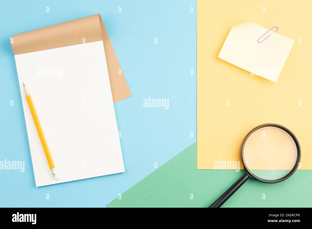 Colored paper background with magnifying glass Stock Photo - Alamy
