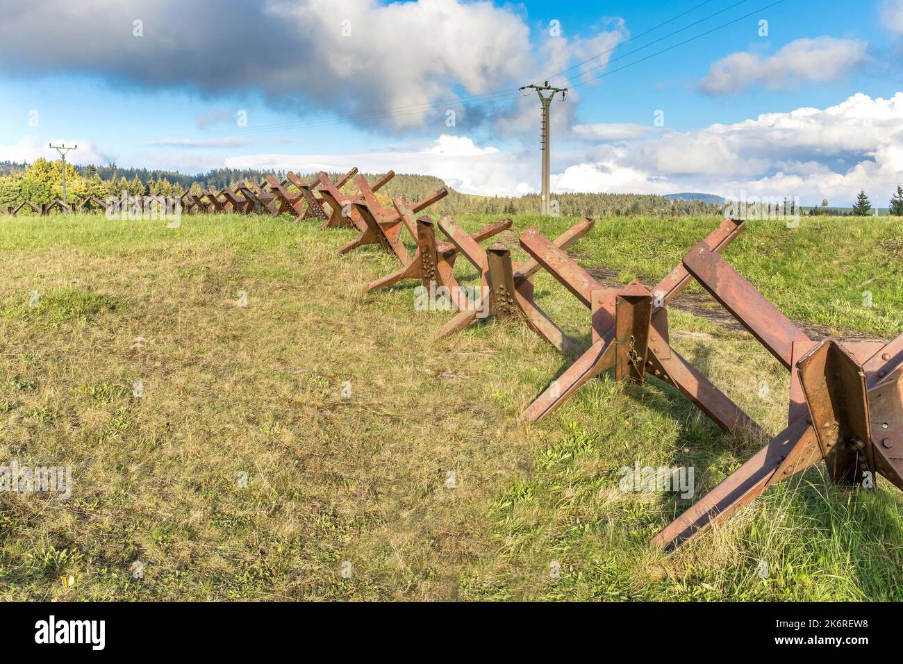 Anti-tank fortifications on the green summer grass. Hedgehog, Defense ...