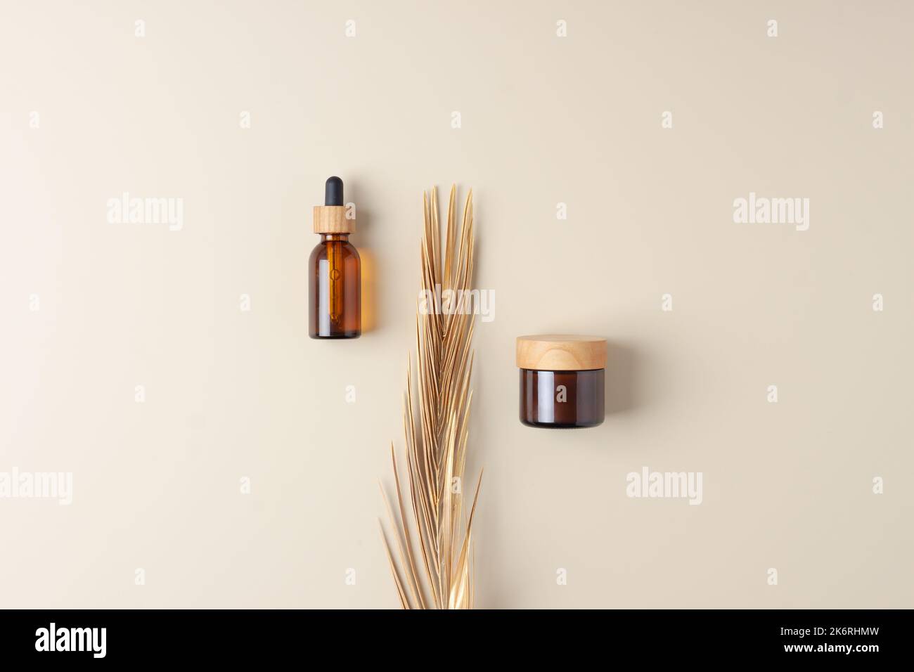 Minimal composition with cosmetic skin care products and palm leaf on ...