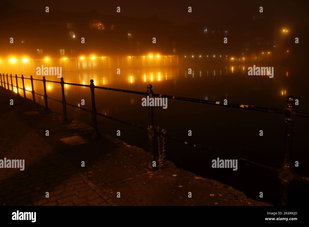 A foggy and misty night by the waterside, with diffuse and spooky light ...