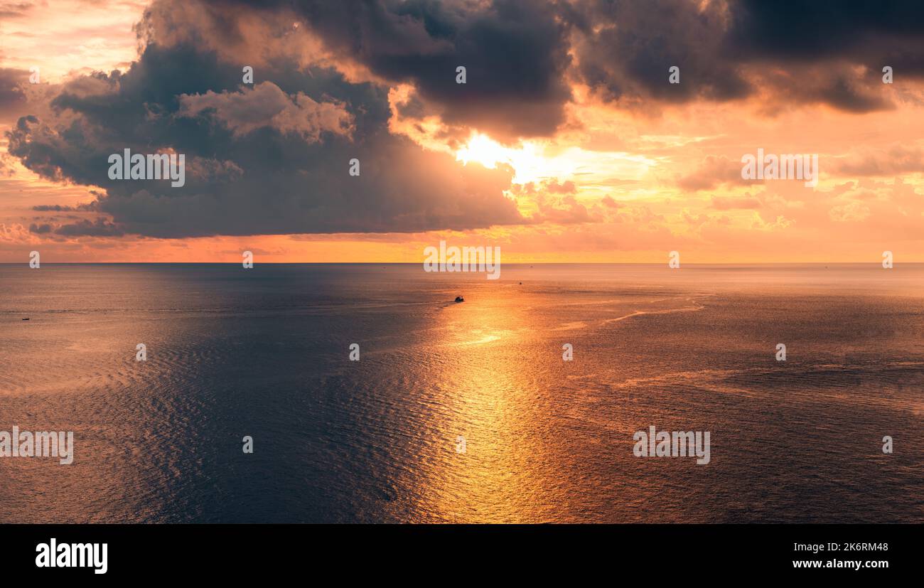 Panorama of colorful sunset over tropical sea and boat sailing in Gulf ...