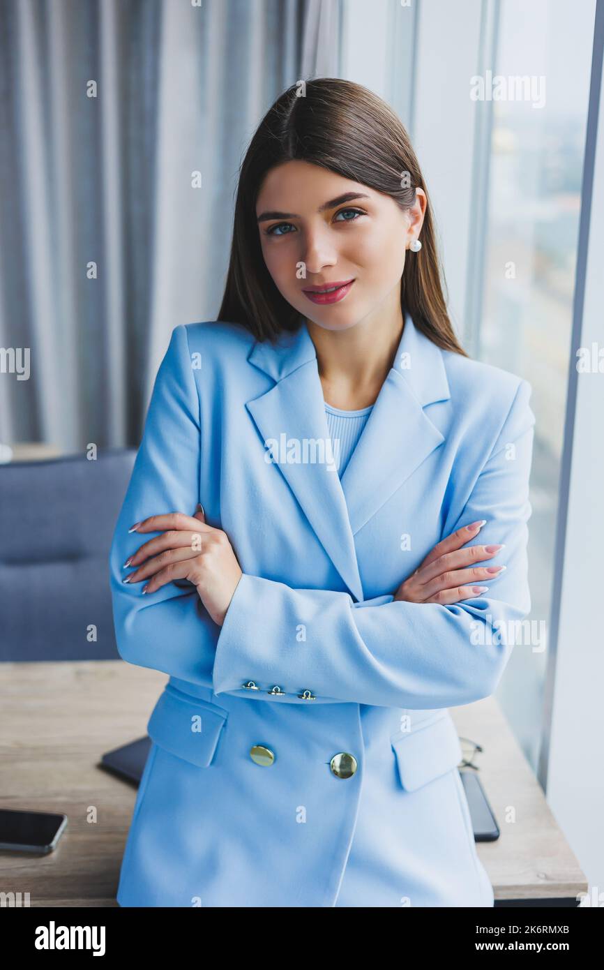 Portrait Of A Pretty Brunette In A Blue Jacket In The Office Near The
