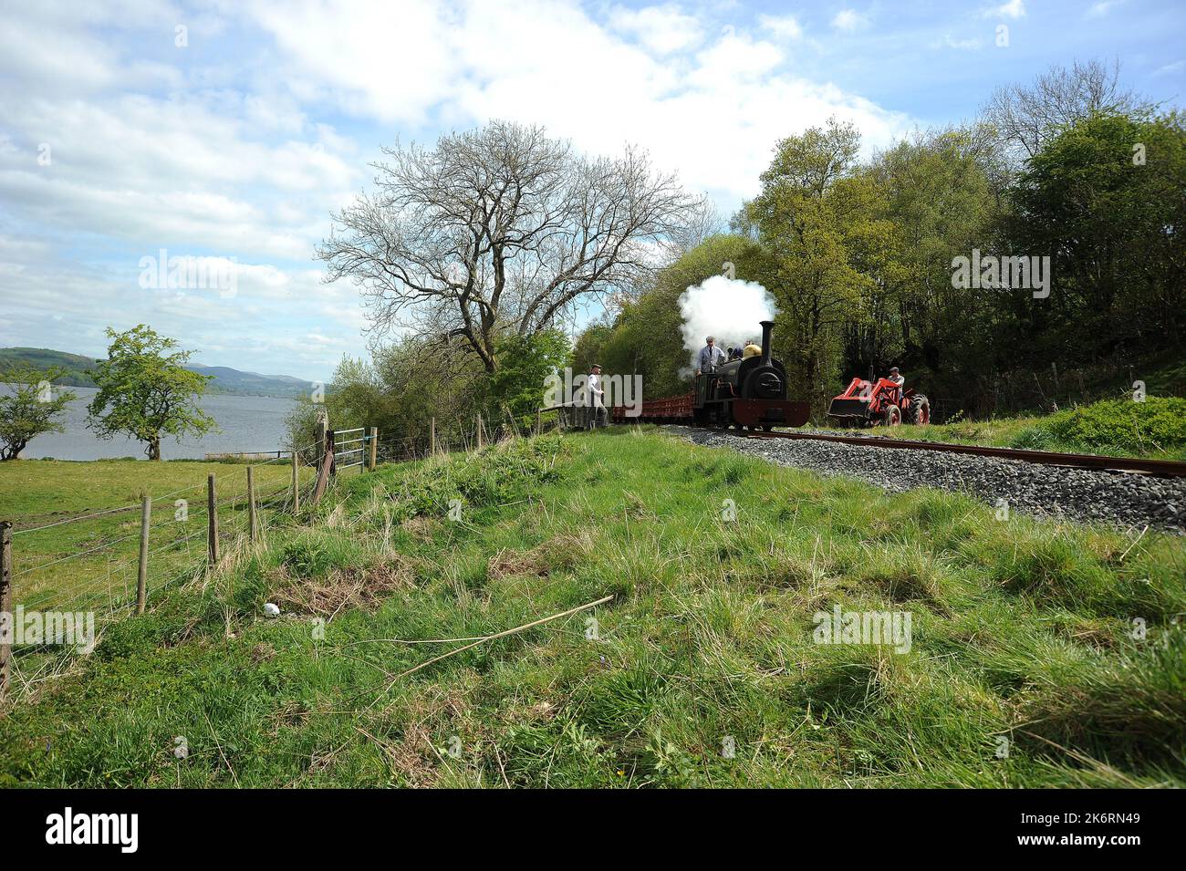 "Winifred" with a train of slate wagons passing a vintage tractor and ...