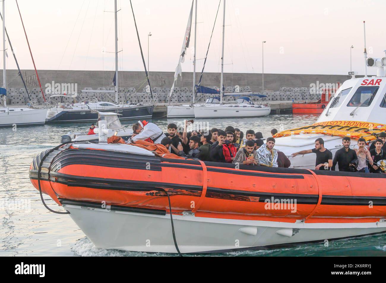 A patrol boat with migrants seen arriving in the port. Patrol boats of ...