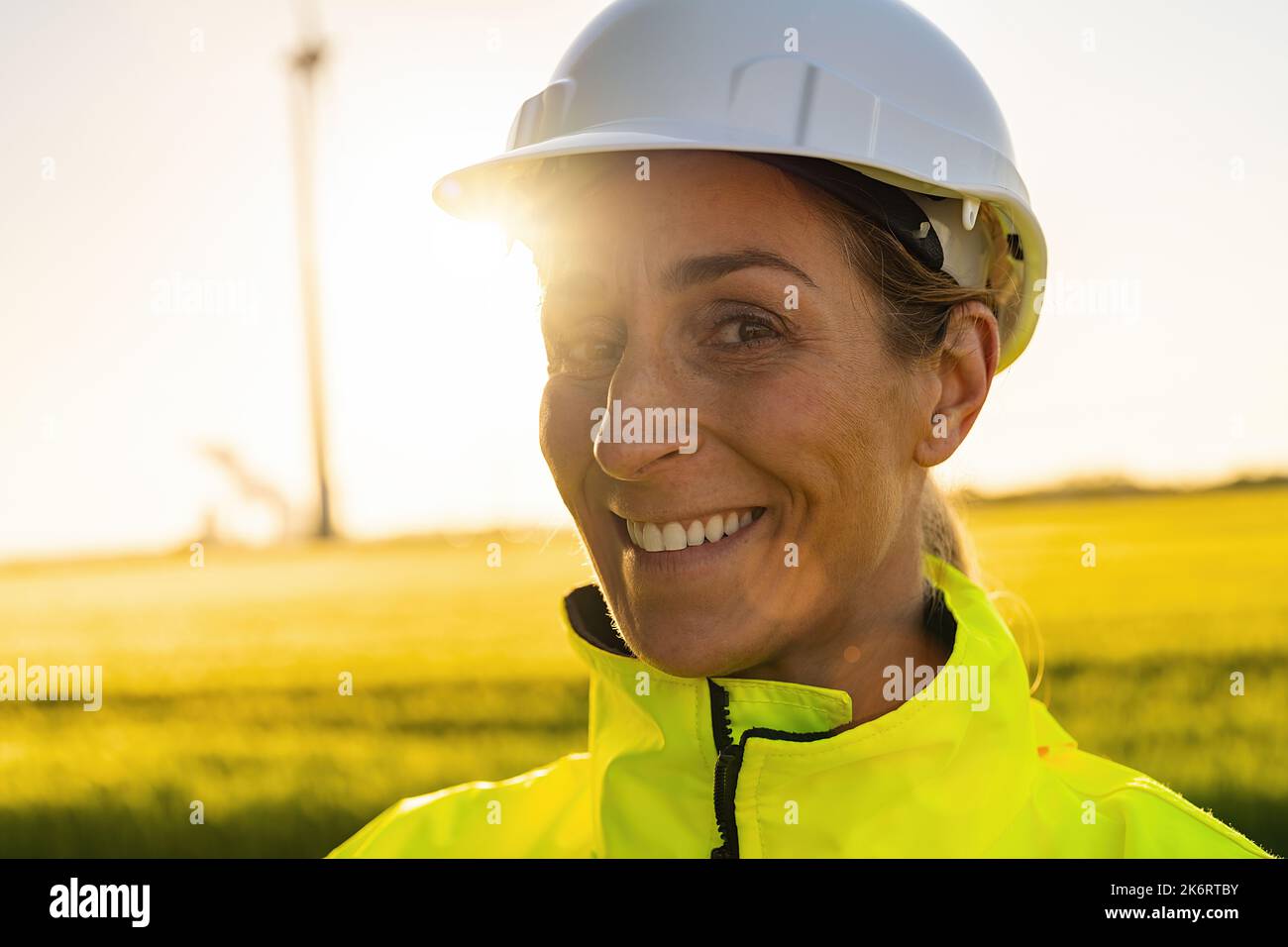 happy female engineer with safety helmet smiling to camera. New Energy ...