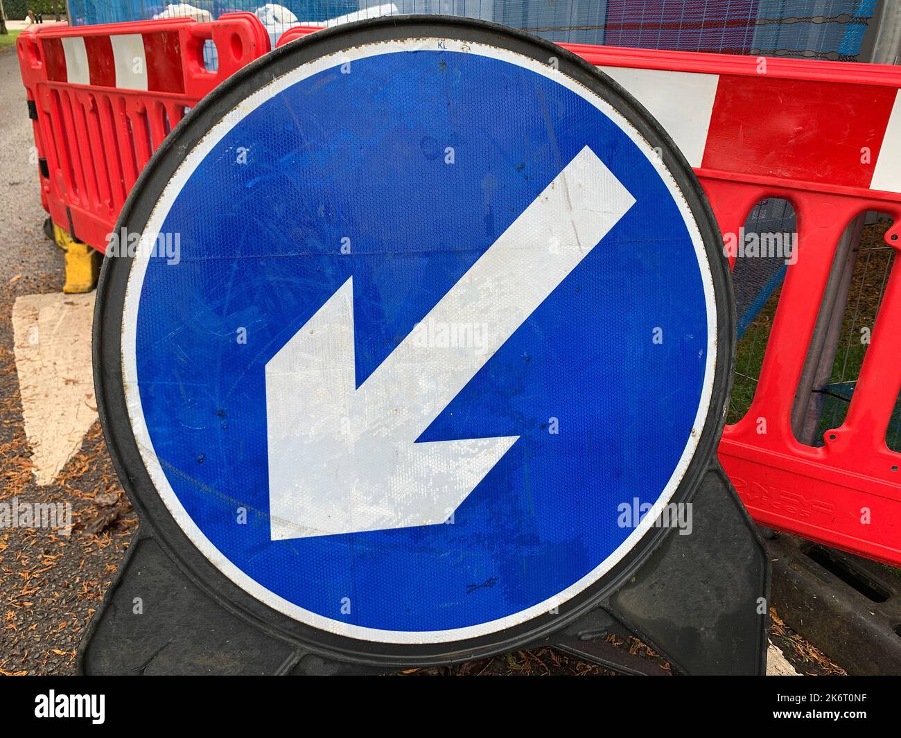 Close up of blue round traffic sign with a white arrow pointing to the ...