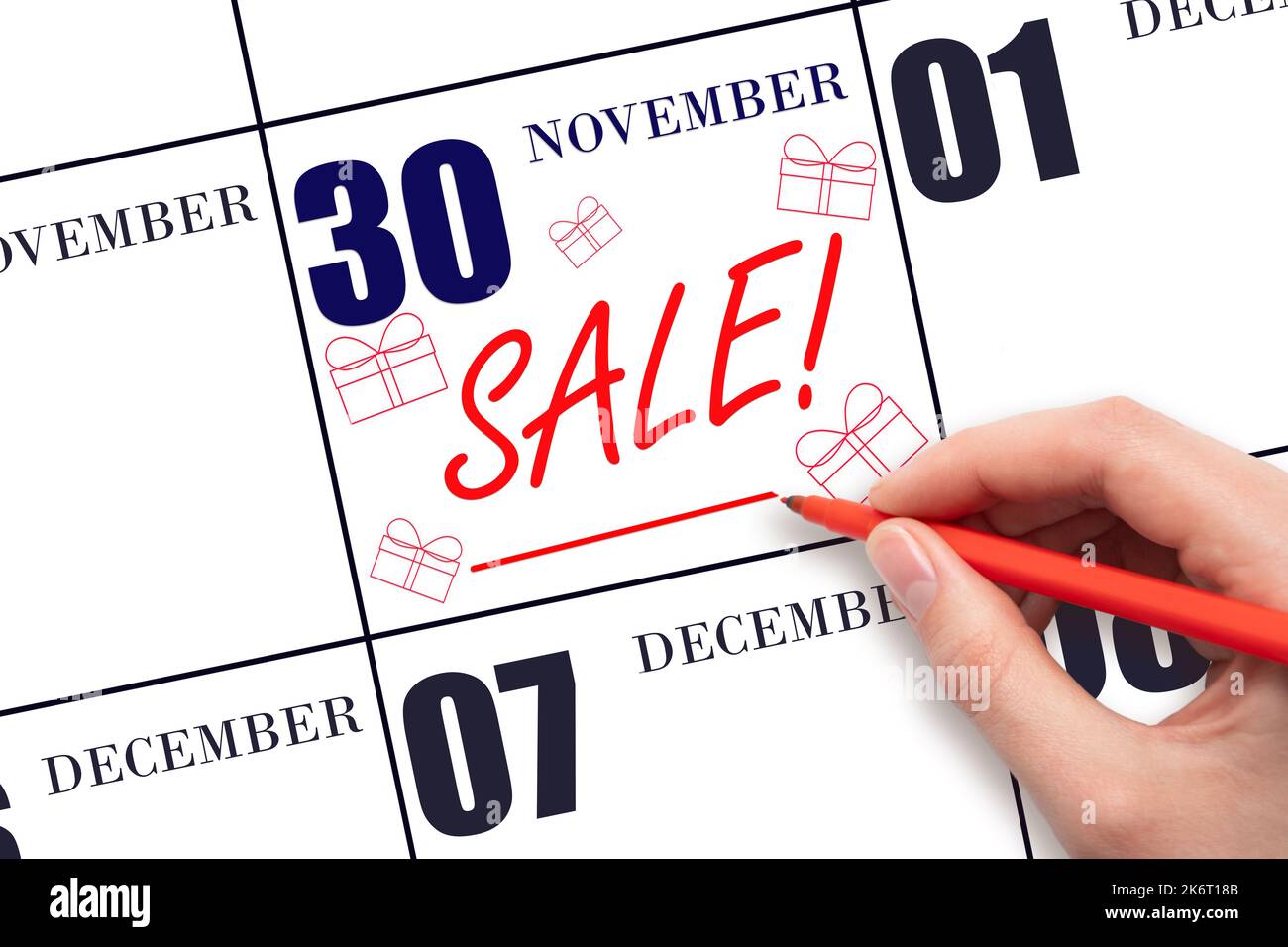 30th day of November. Hand writing text SALE and drawing gift boxes on ...