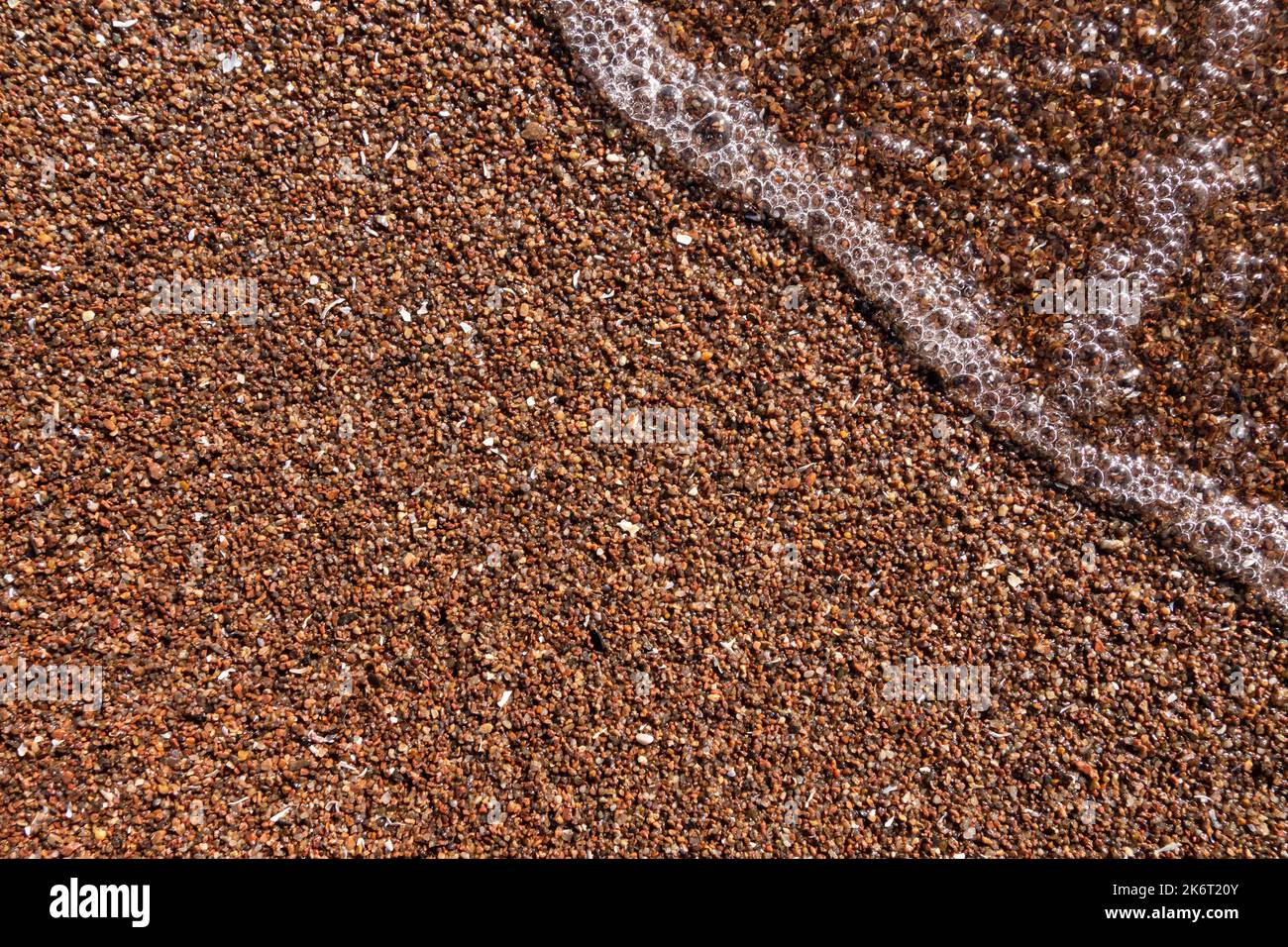 A small wave running on a sandy beach. Background for a banner on ...