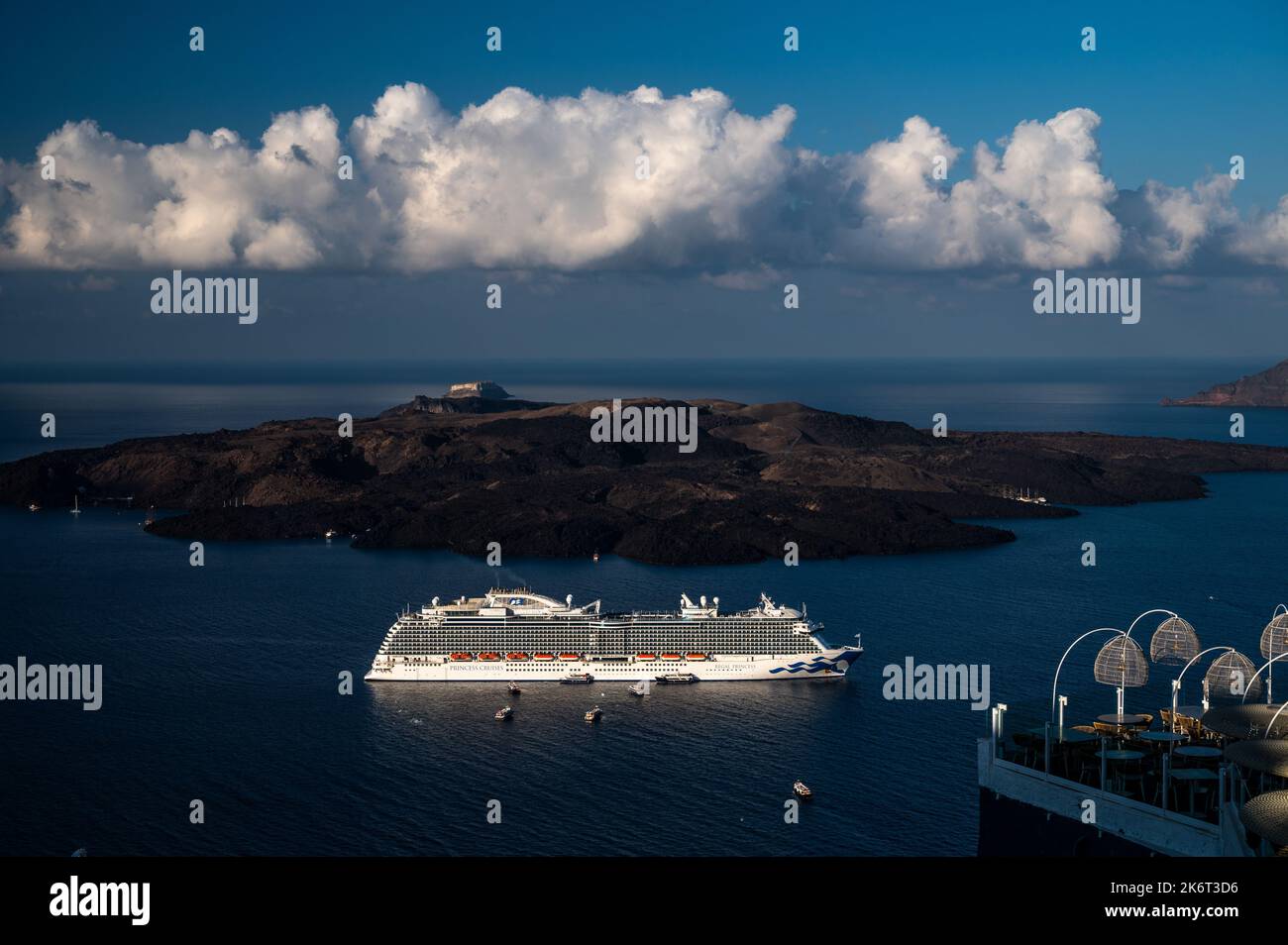 A cruise ship is seen arriving in Santorini with tourists. Santorini is ...