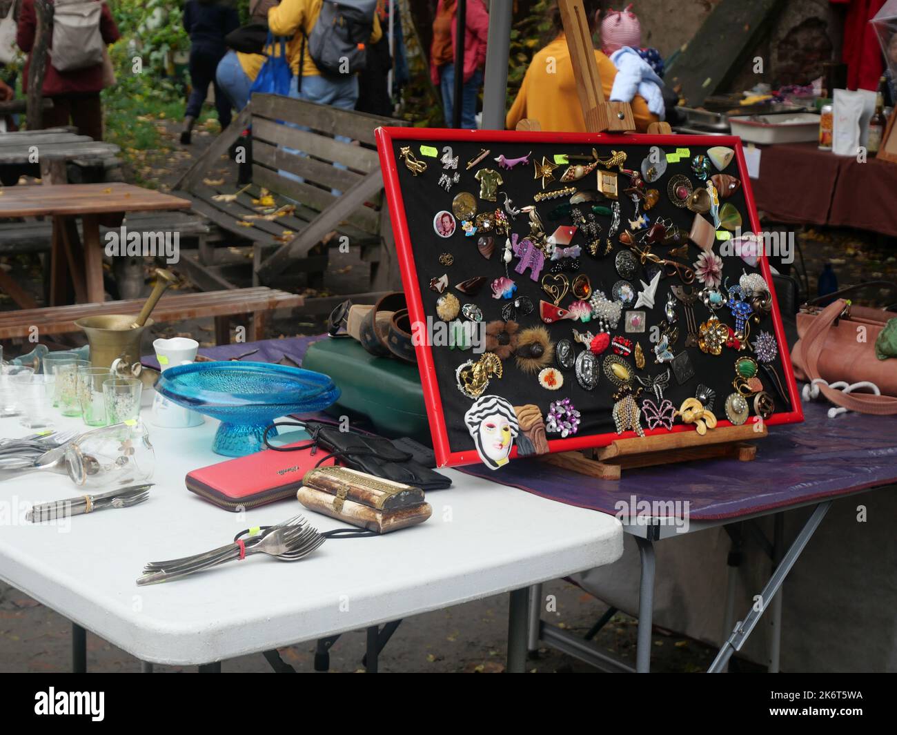 Flea market in a garden, many thing to sell, unrecognisable people and ...