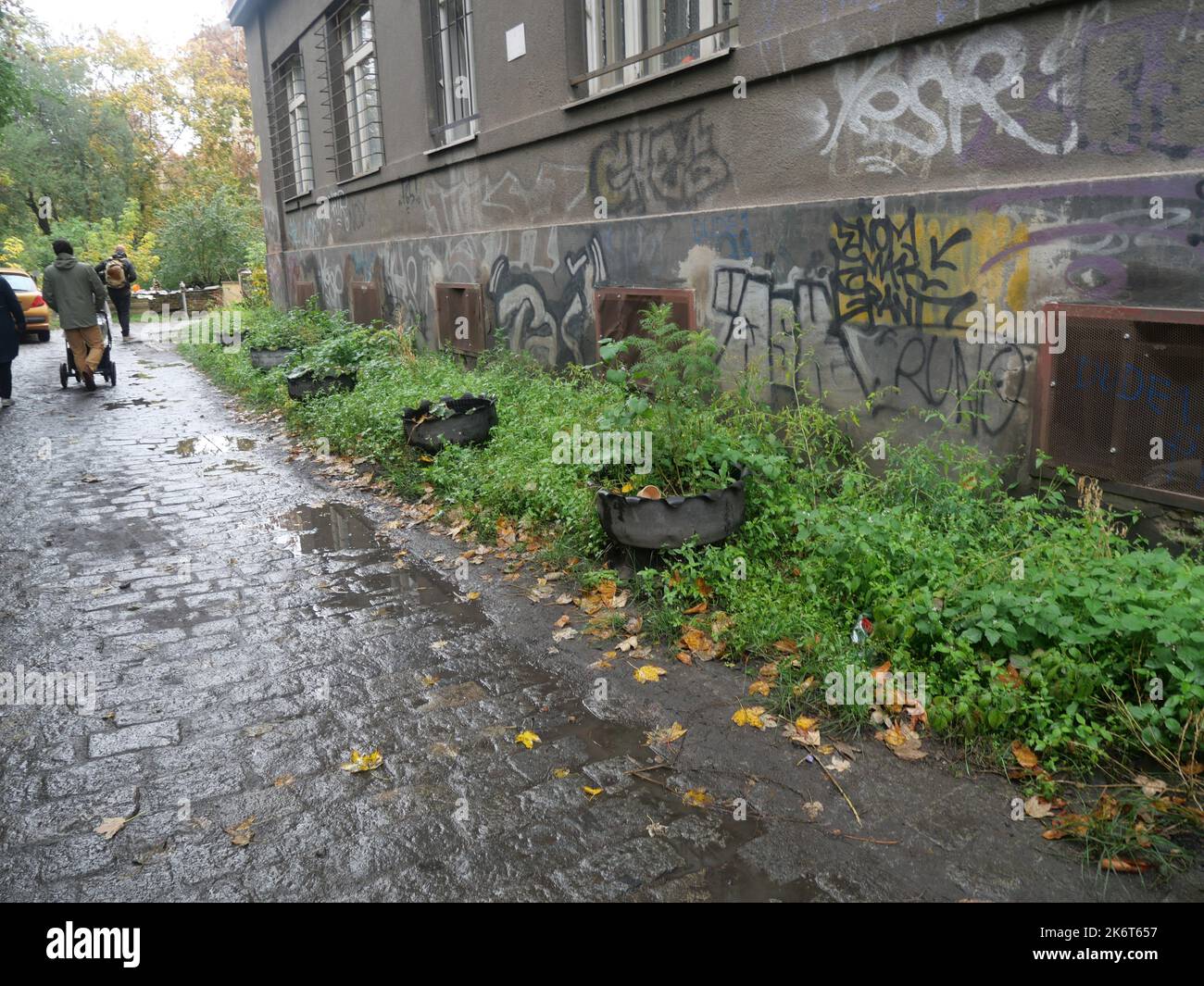 Unrecognisable people walking on an old dirty cobblestone road. Large ...