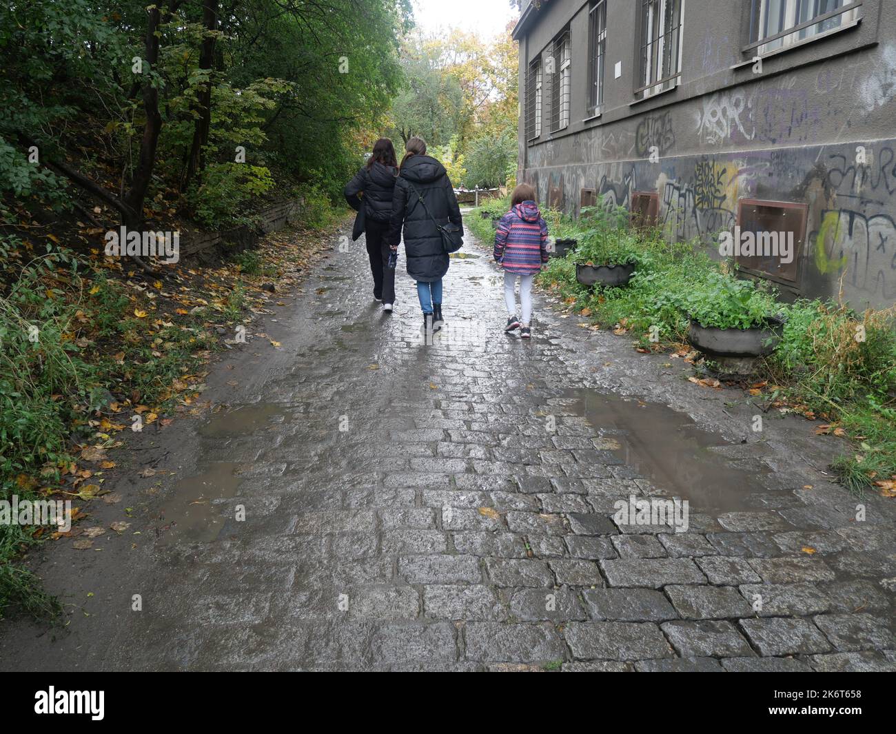Unrecognisable people walking on an old dirty cobblestone road. Large ...