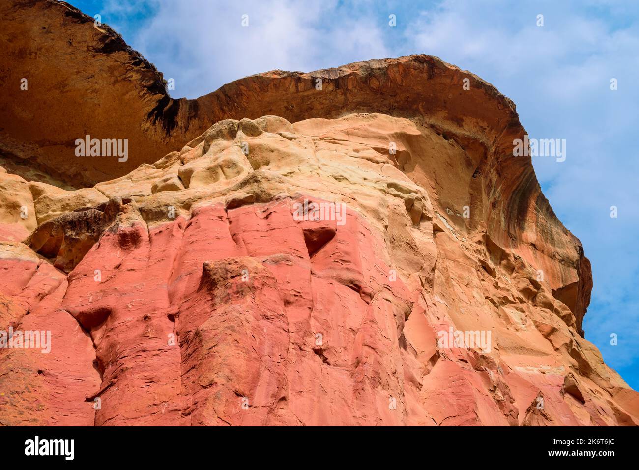 The towering cliff and overhanging ledge of Mushroom Rock, a colorful ...