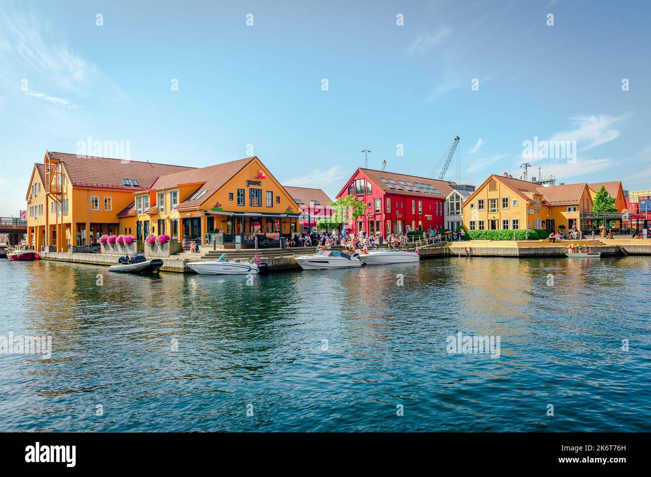 People enjoy a sunny day at Fiskebrygga (The Fish Wharf) in Kristiansand, Norway. Wood-fronted ...
