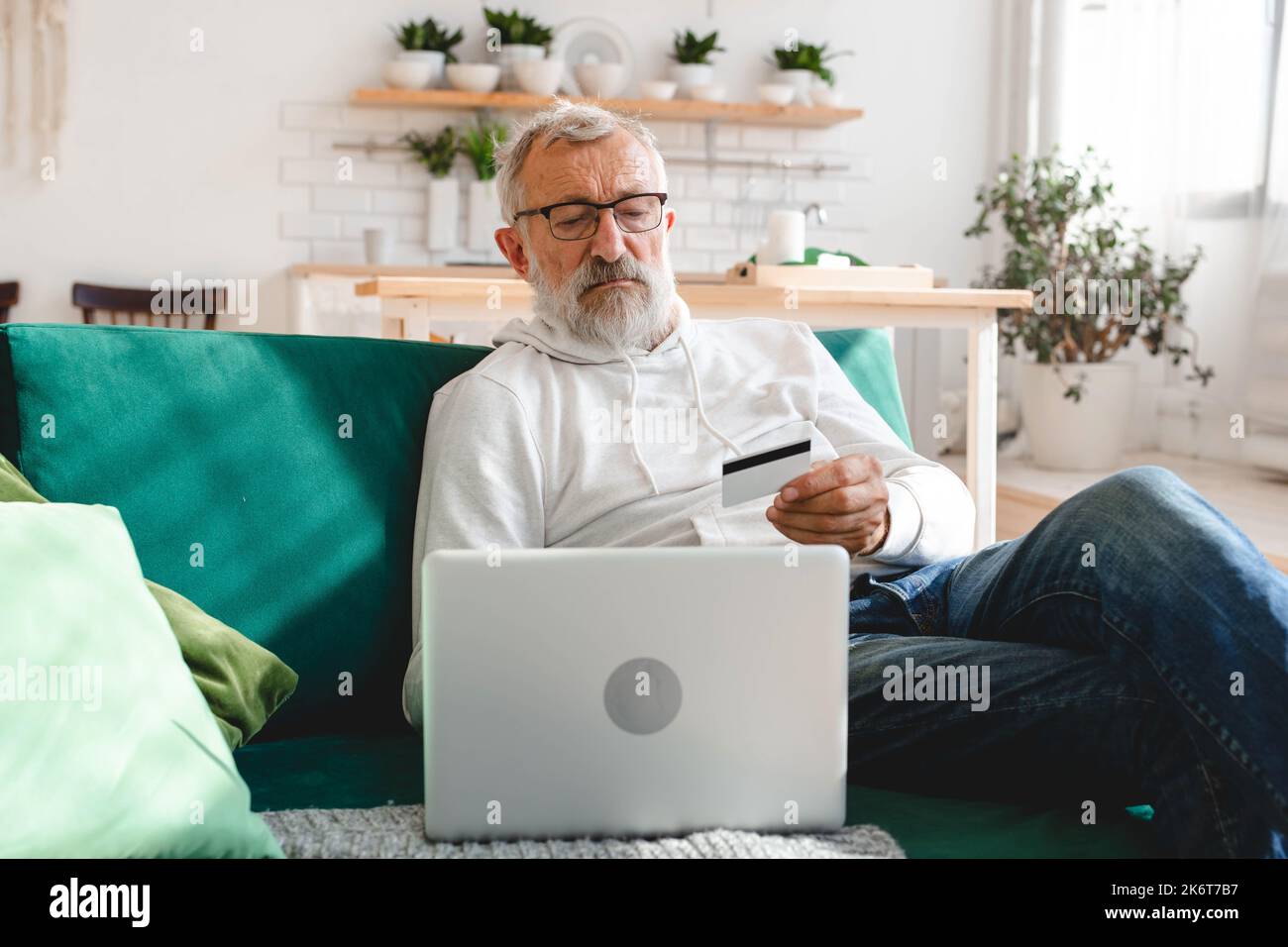Senior elderly man making online payments using laptop. Old grandfather ...