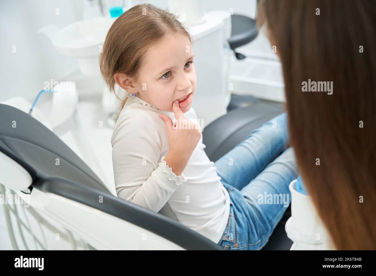 Pre-teen girl complaining of toothache to doctor Stock Photo - Alamy