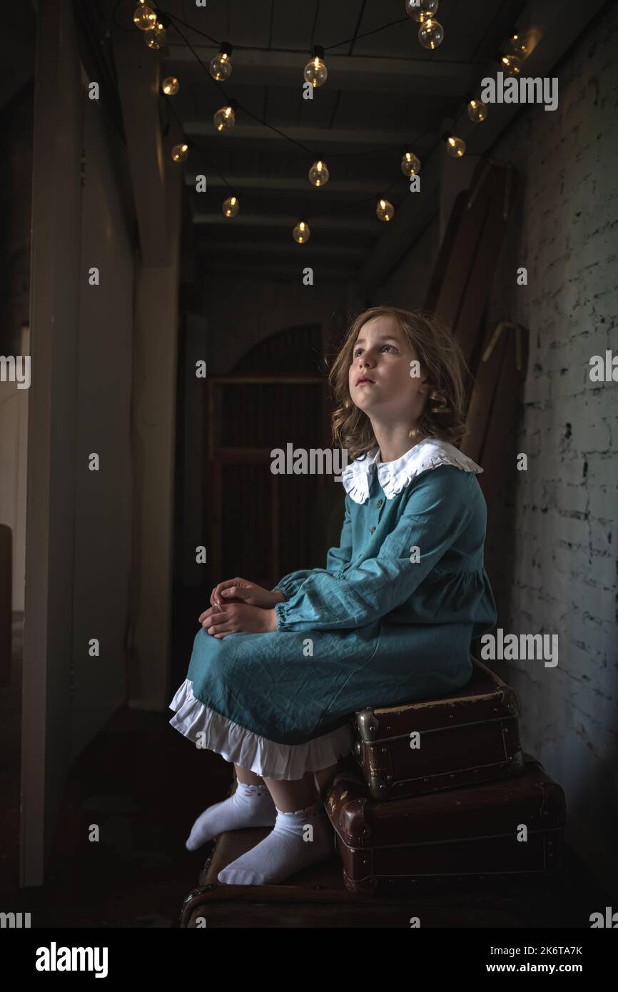 a little girl sits alone in a dark hallway. fear, loneliness Stock ...