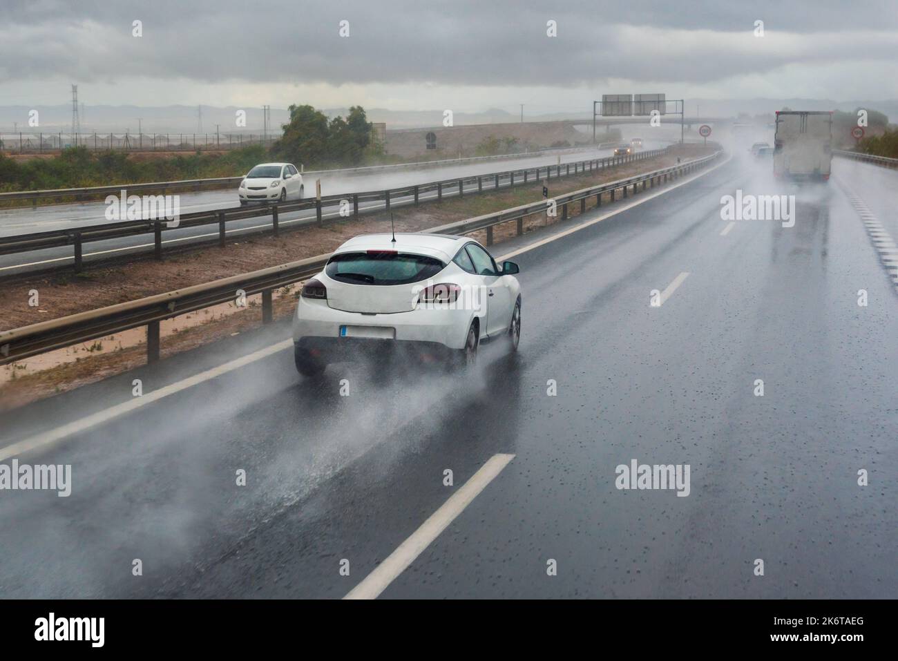 Vehicles circulating on a highway flooded by water falling from a heavy ...