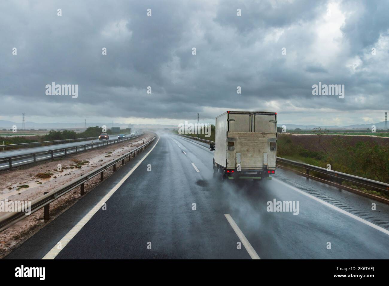 Vehicles circulating on a highway flooded by water falling from a heavy ...