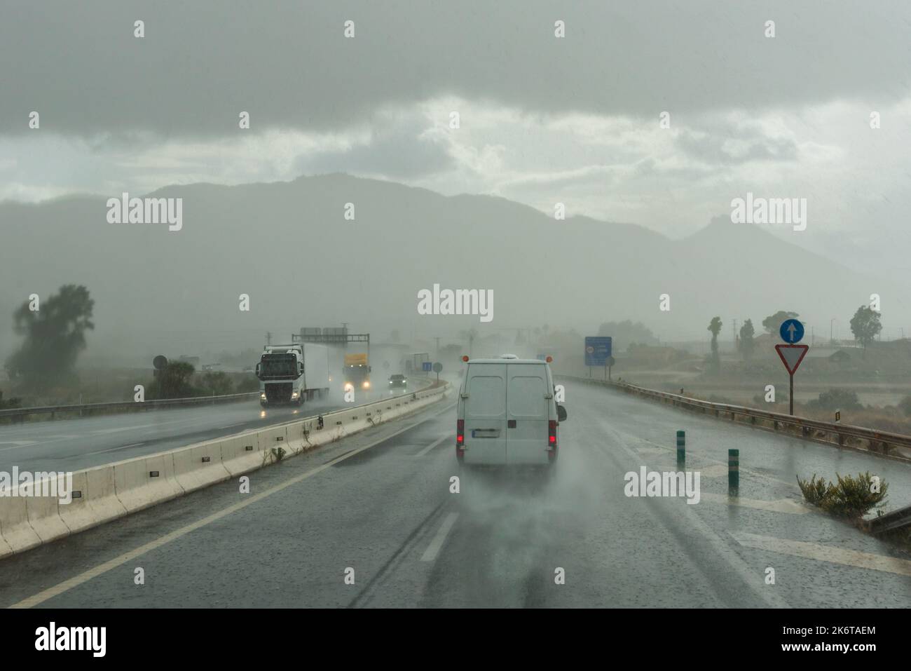 Vehicles circulating on a highway flooded by water falling from a heavy ...