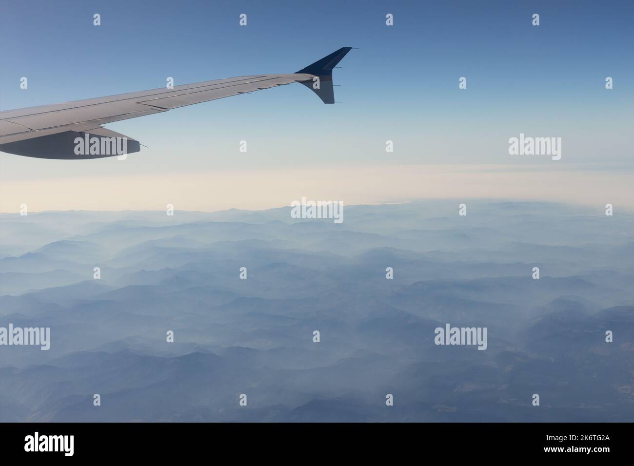 Passenger view from a commercial jet flying over smoke from wildfires ...