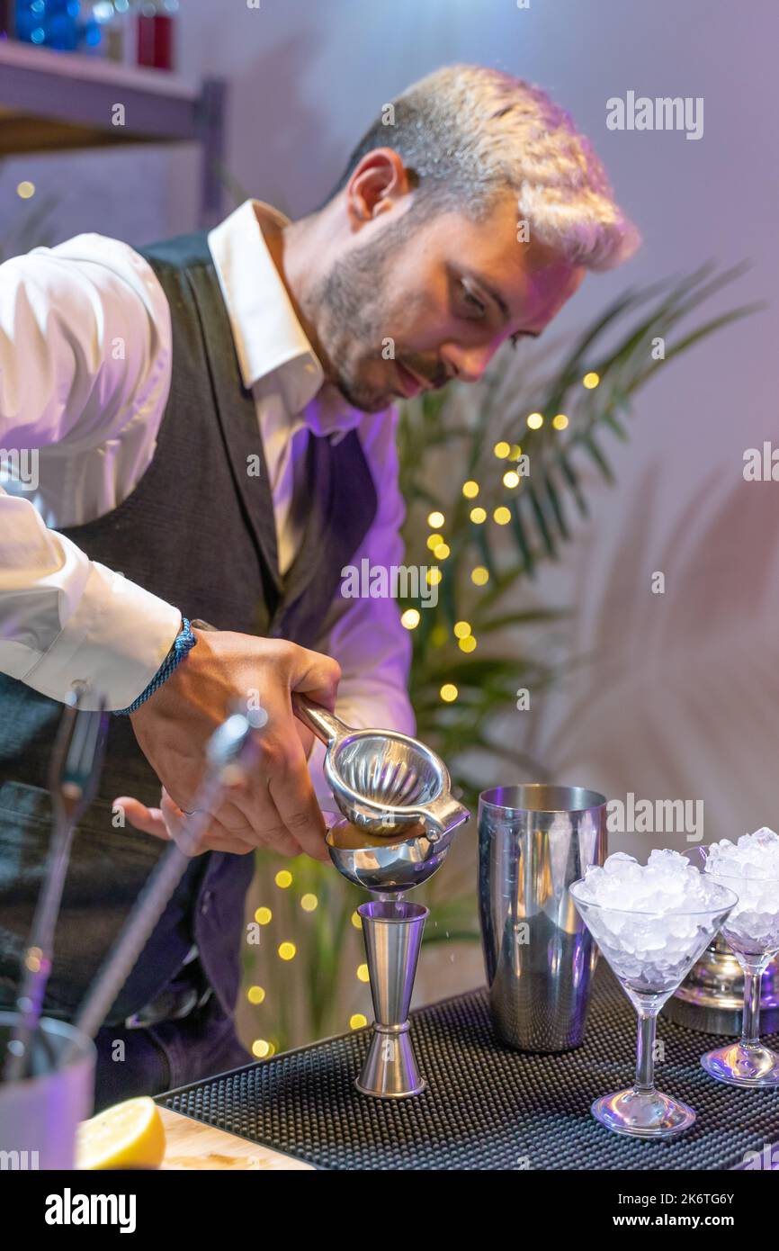 Barman making cocktail Mojito in night club adding ingredients and ...