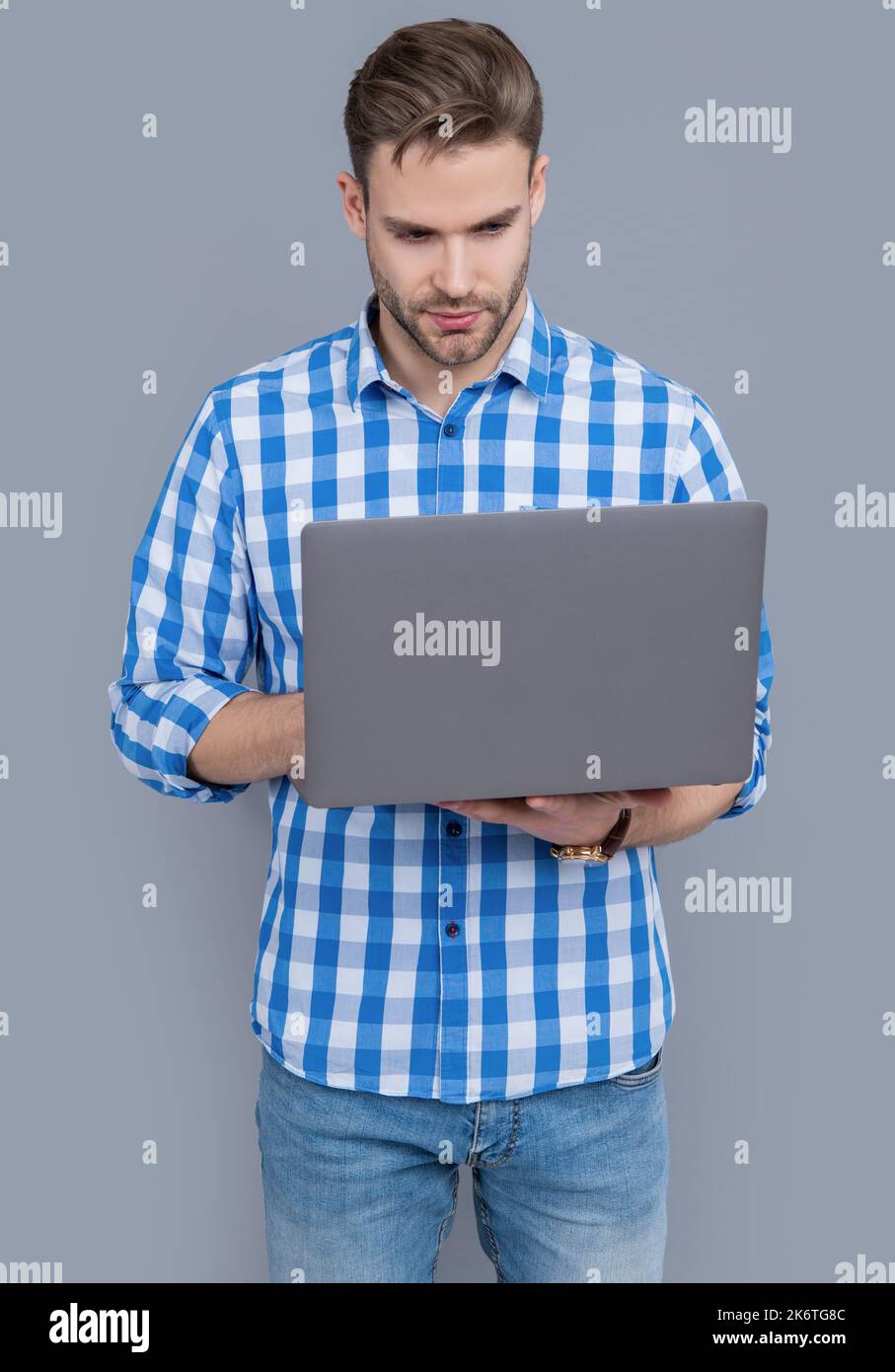 Computer programmer studio. Software developer using laptop computer. Serious man typing in ...