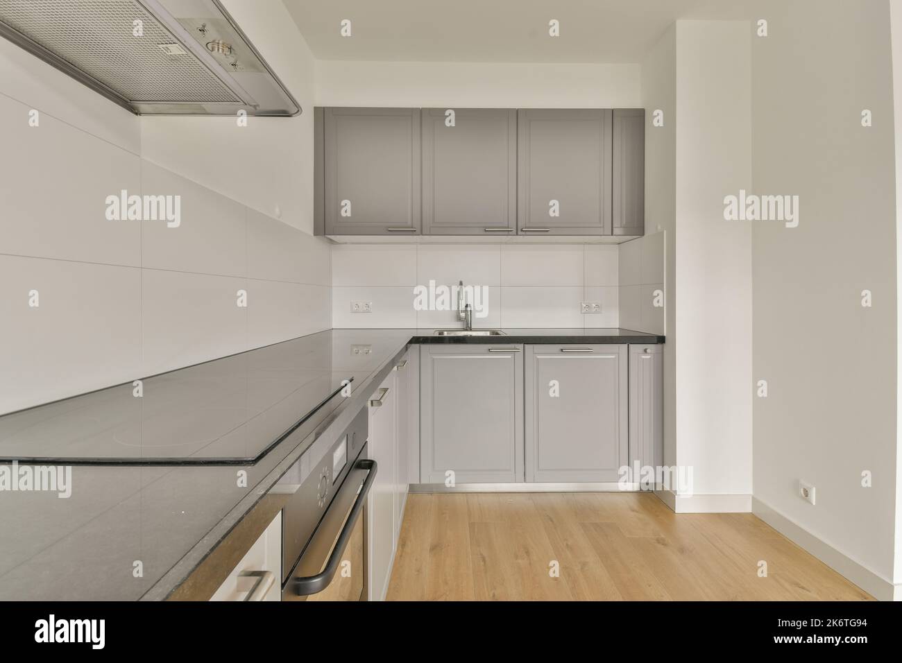 Interior of empty white kitchen with windows and wooden parquet floor ...