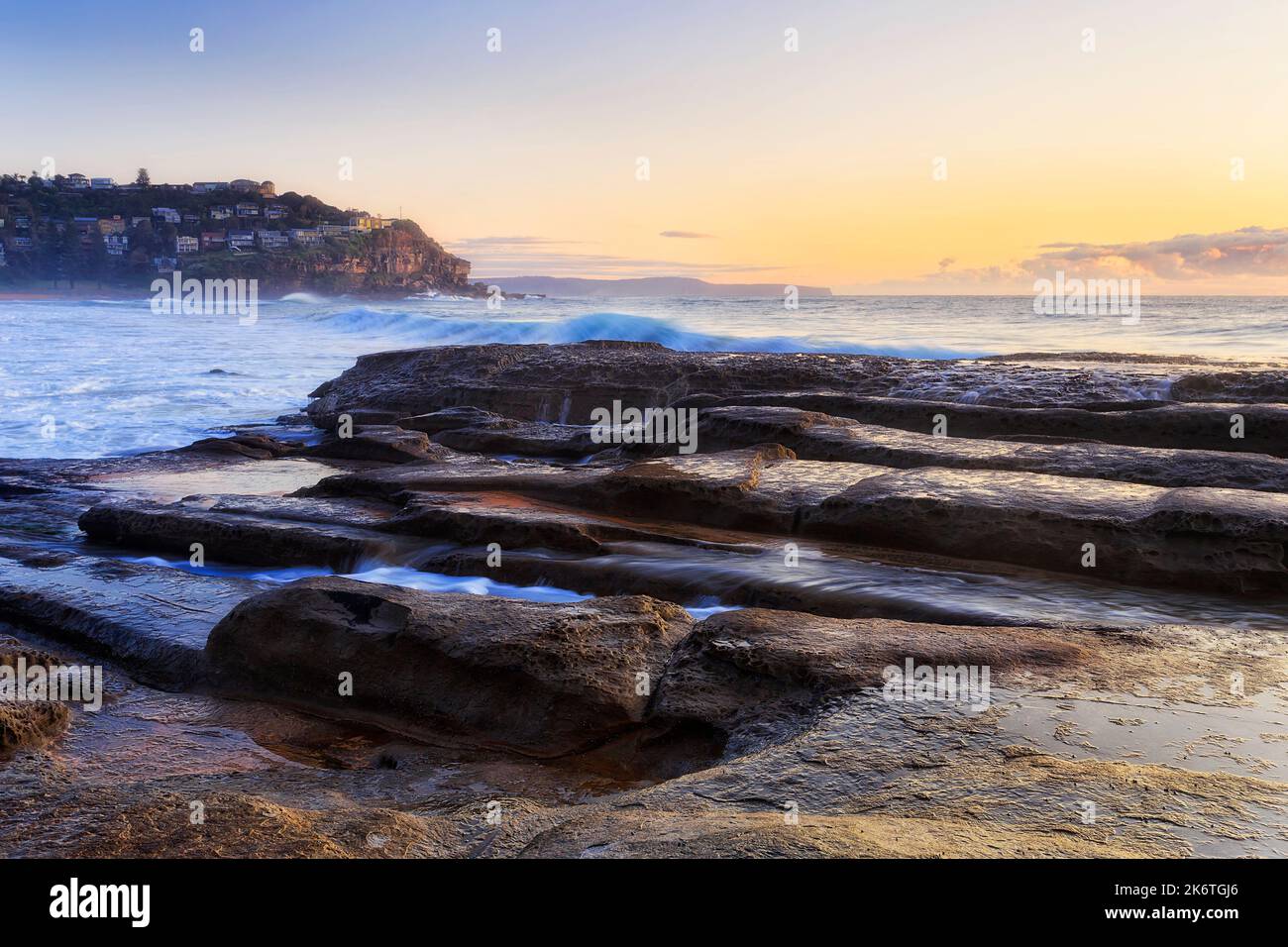 Eroded sandstoen rocks on Whale beach of Sydney Pacific coast in view ...