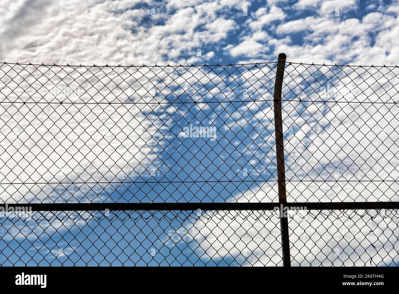 View through wire mesh fence, wire mesh on fence, cloudy sky, symbol ...