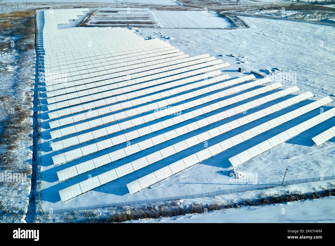 Aerial view of snow covered sustainable electric power plant with rows ...