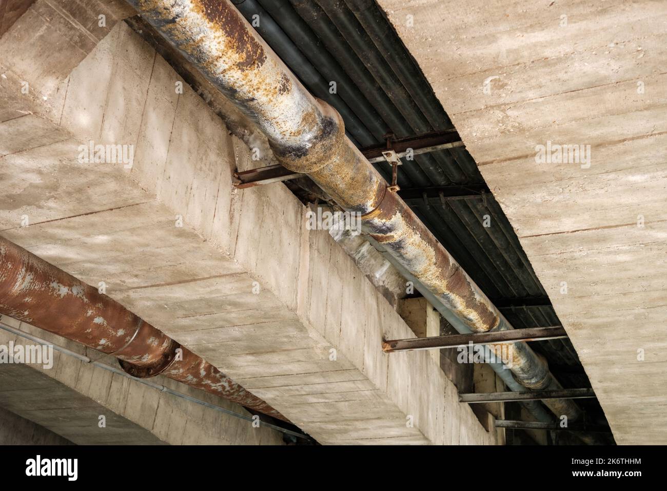 Large rusty pipes under a bridge in poor condition Stock Photo - Alamy