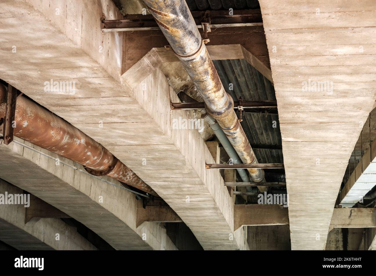 Large rusty pipes under a bridge in poor condition Stock Photo - Alamy