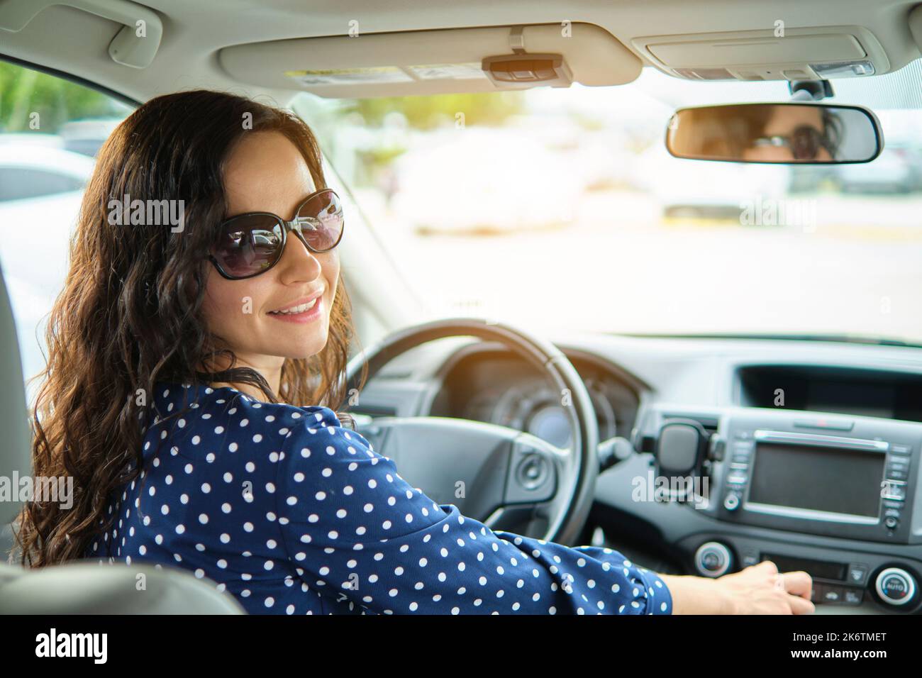 Portrait of attractive young woman in casual dress looking over her ...