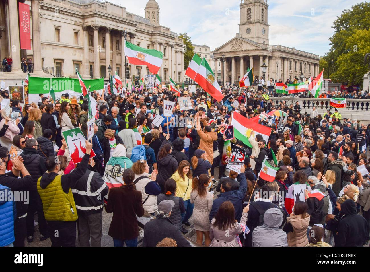 London, UK. 15th Oct, 2022. Protesters hold Iranian flags in Trafalgar ...