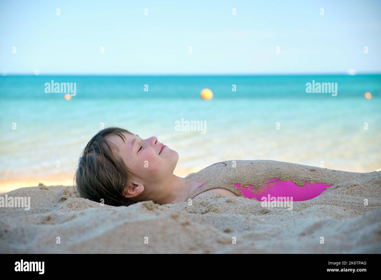 Young Smiling Girl In Bathing Suit Laying With Closed Eyes Covered With