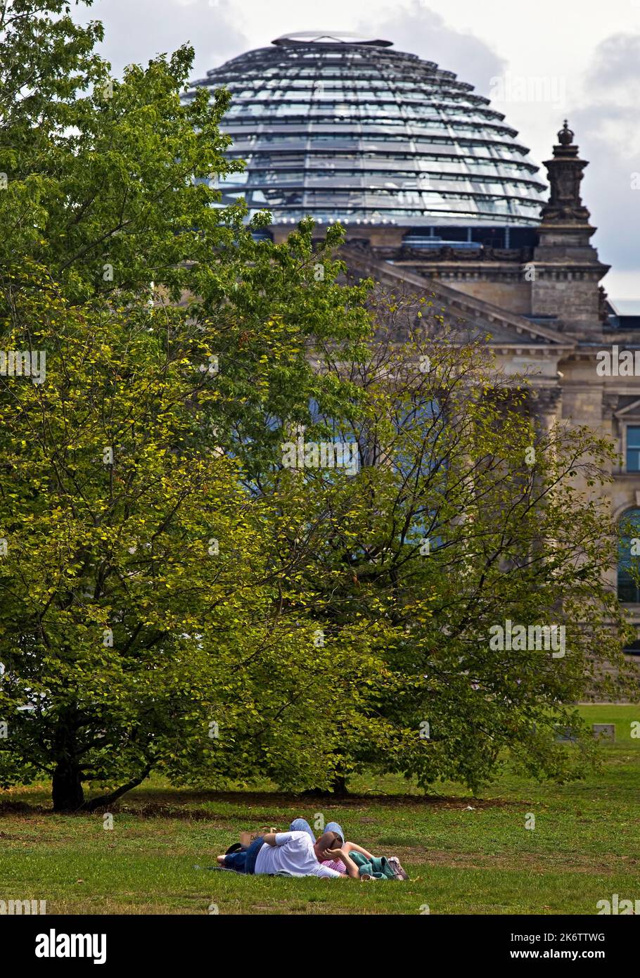 Two people lying on the Platz der Republik in front of the Reichstag ...