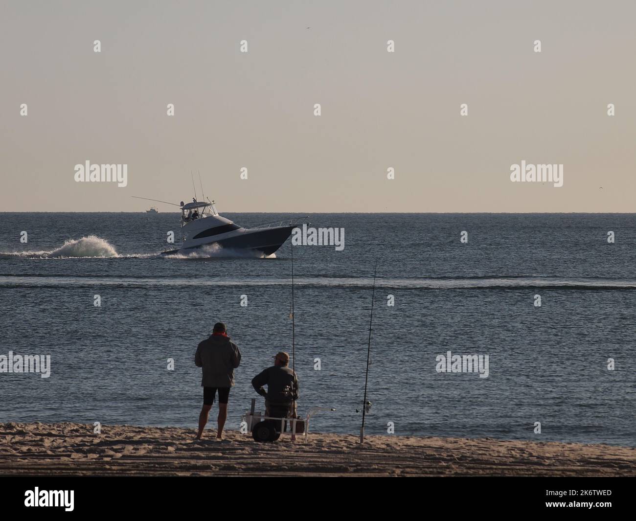 Fishermen on a beach watching a boat hi-res stock photography and ...