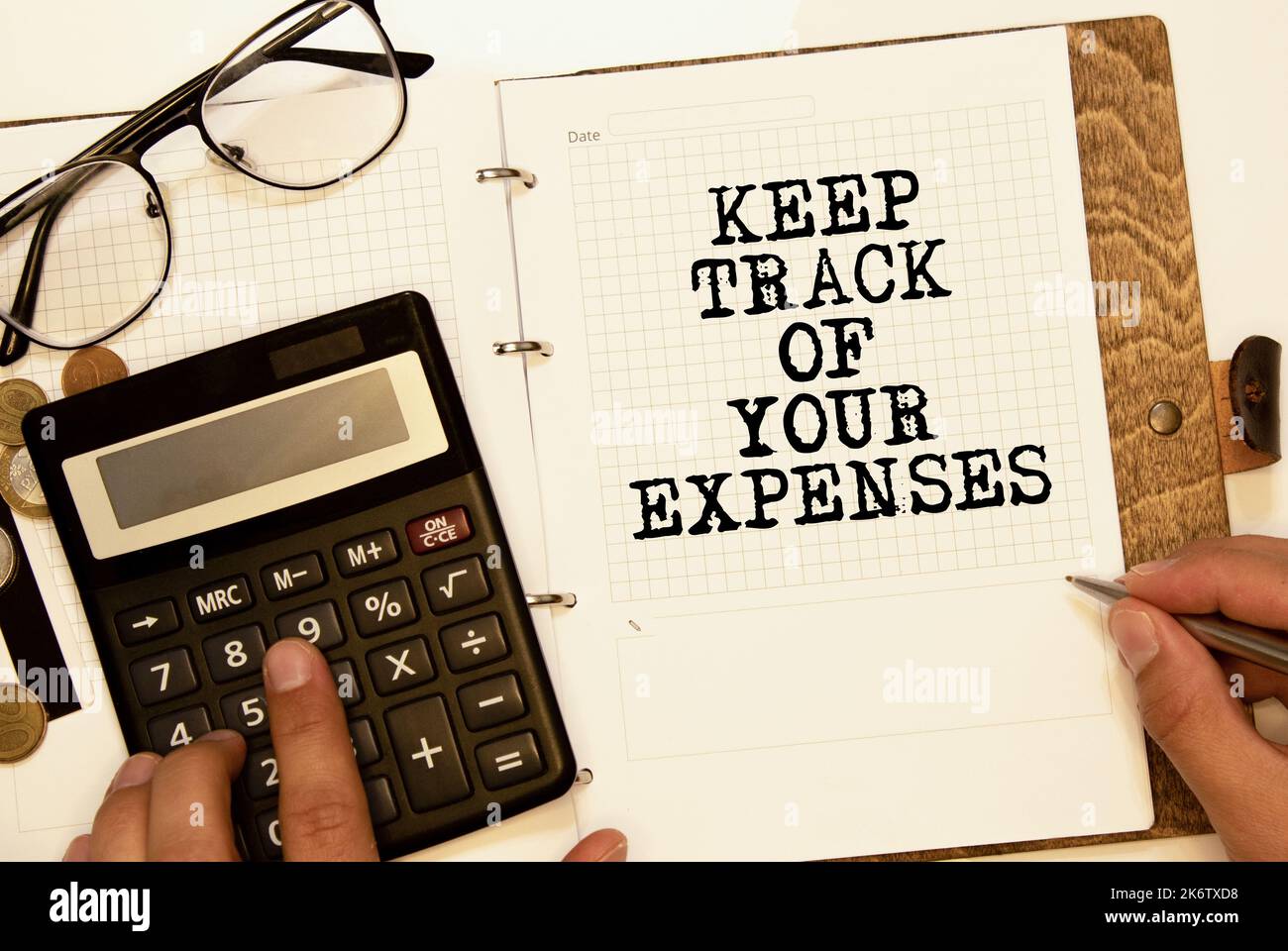 White card with the text Keep track of your expenses on wooden desk ...