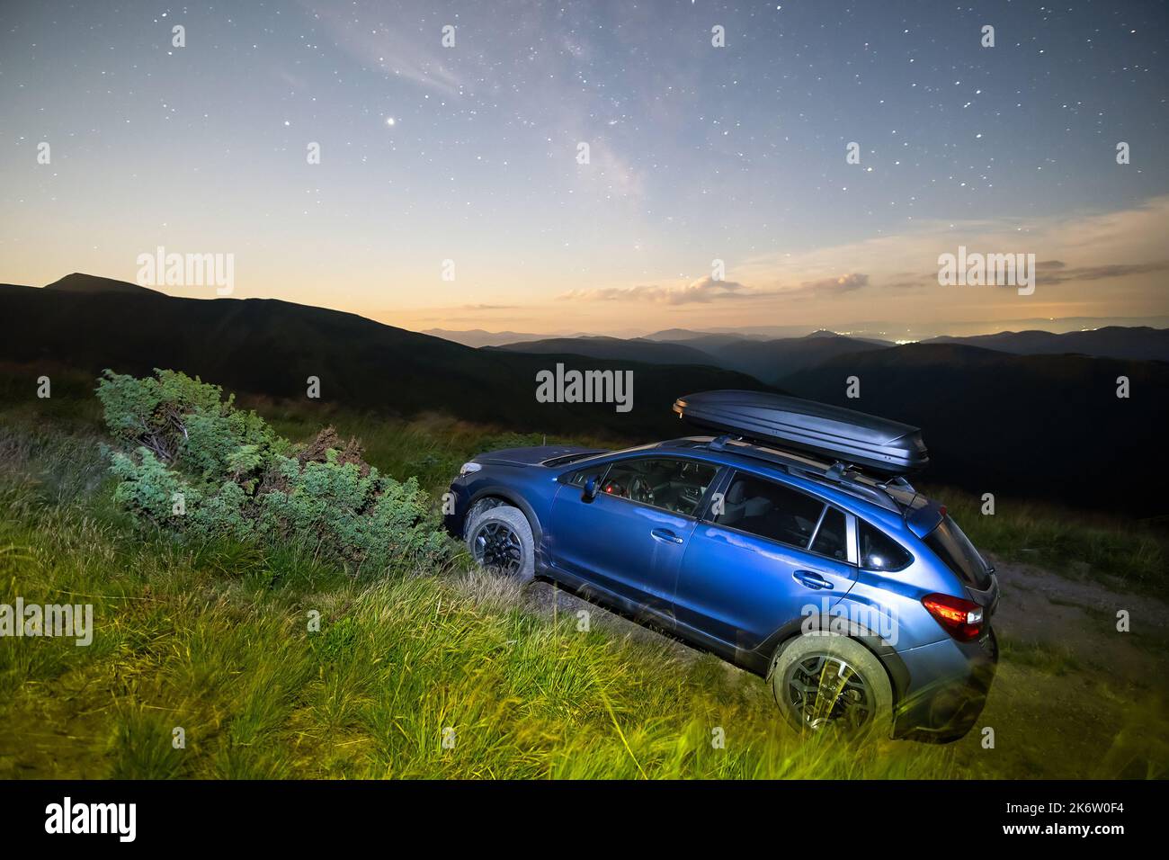 Blue offroad SUV car with roof trunk on background of very beautiful ...