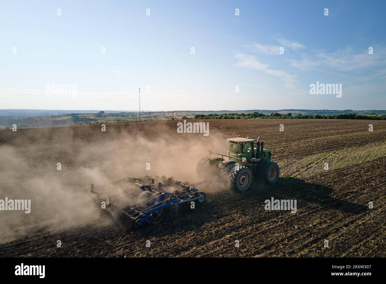 Aerial view of tractor plowing agriculural farm field preparing soil ...