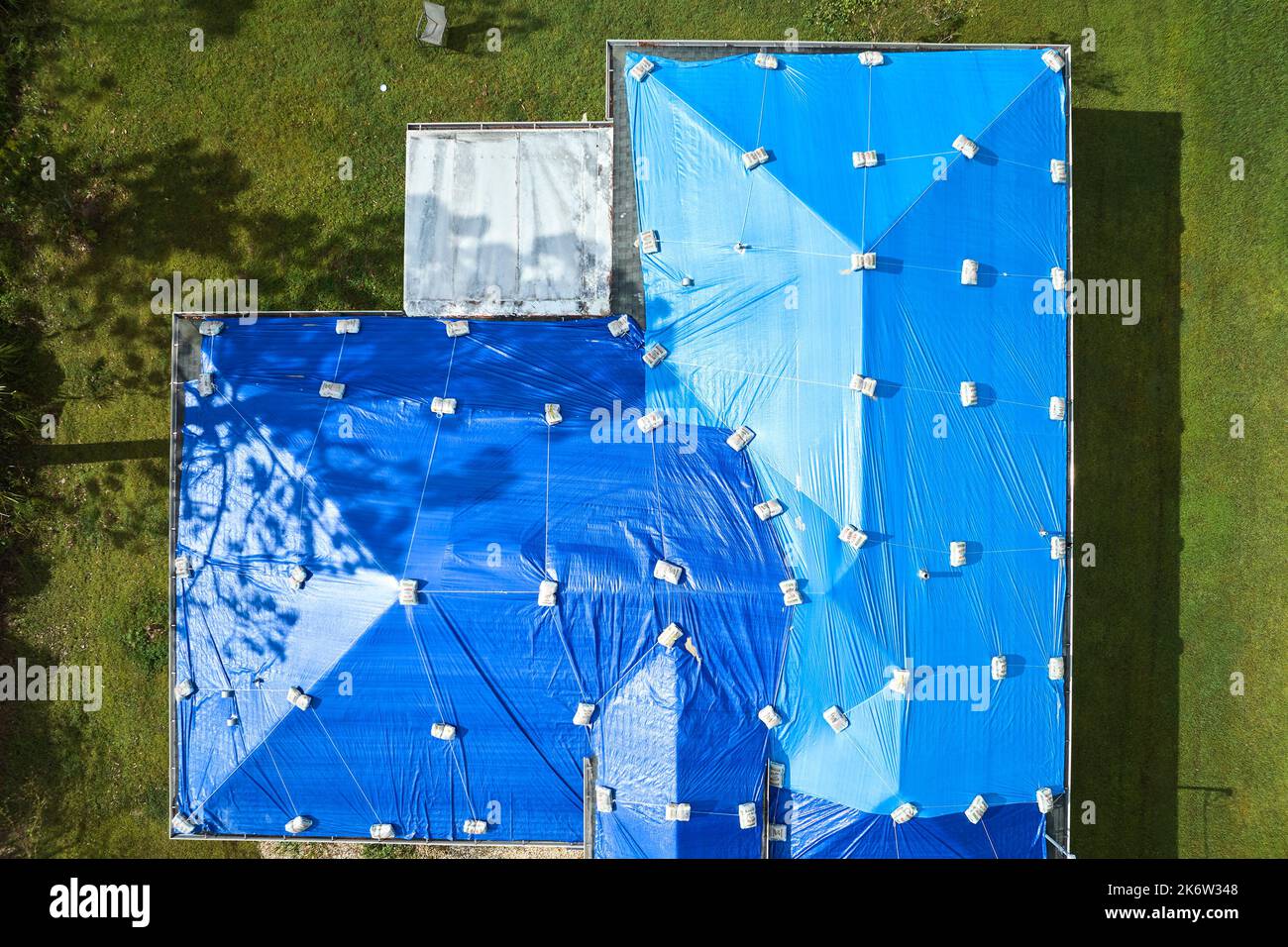 Top view of leaking house roof covered with protective tarp sheets ...