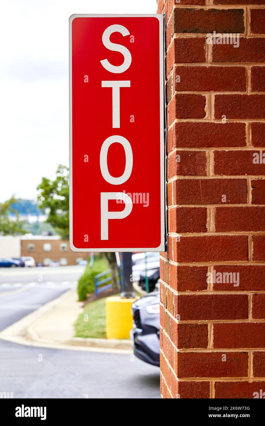 Stop sign mounted on the side of a on brick wall Stock Photo - Alamy