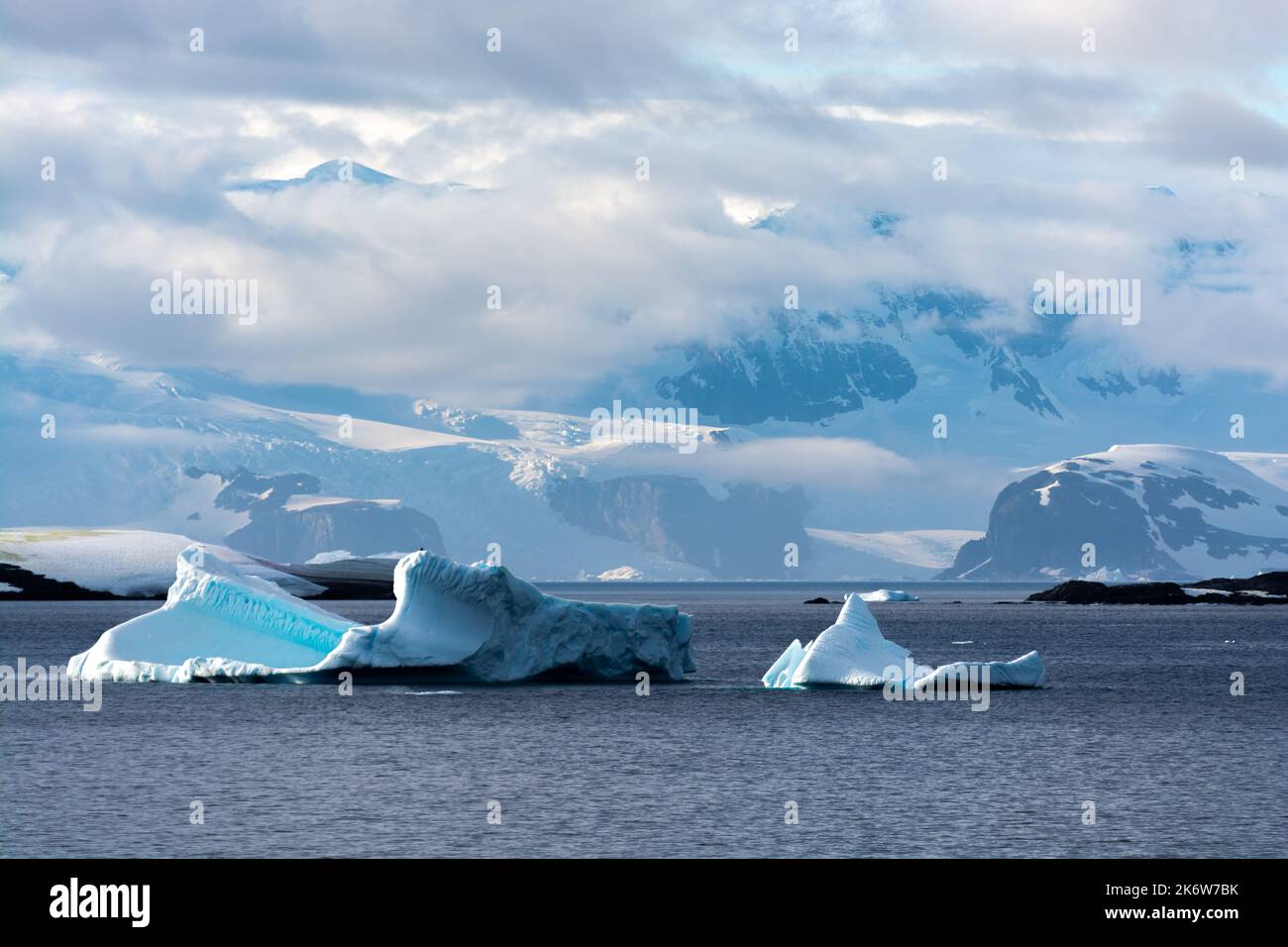 icebergs in dallmann bay with snow covered mountain backdrop. antarctic ...