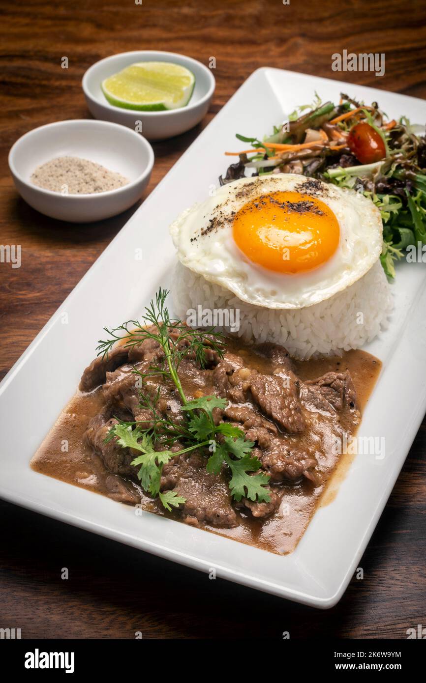 Traditional cambodian Lok Lak stir fried beef with rice meal on wood ...