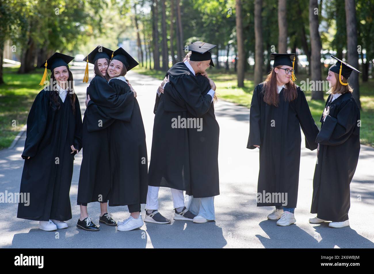 Group of happy graduates in robes hugging outdoors Stock Photo - Alamy