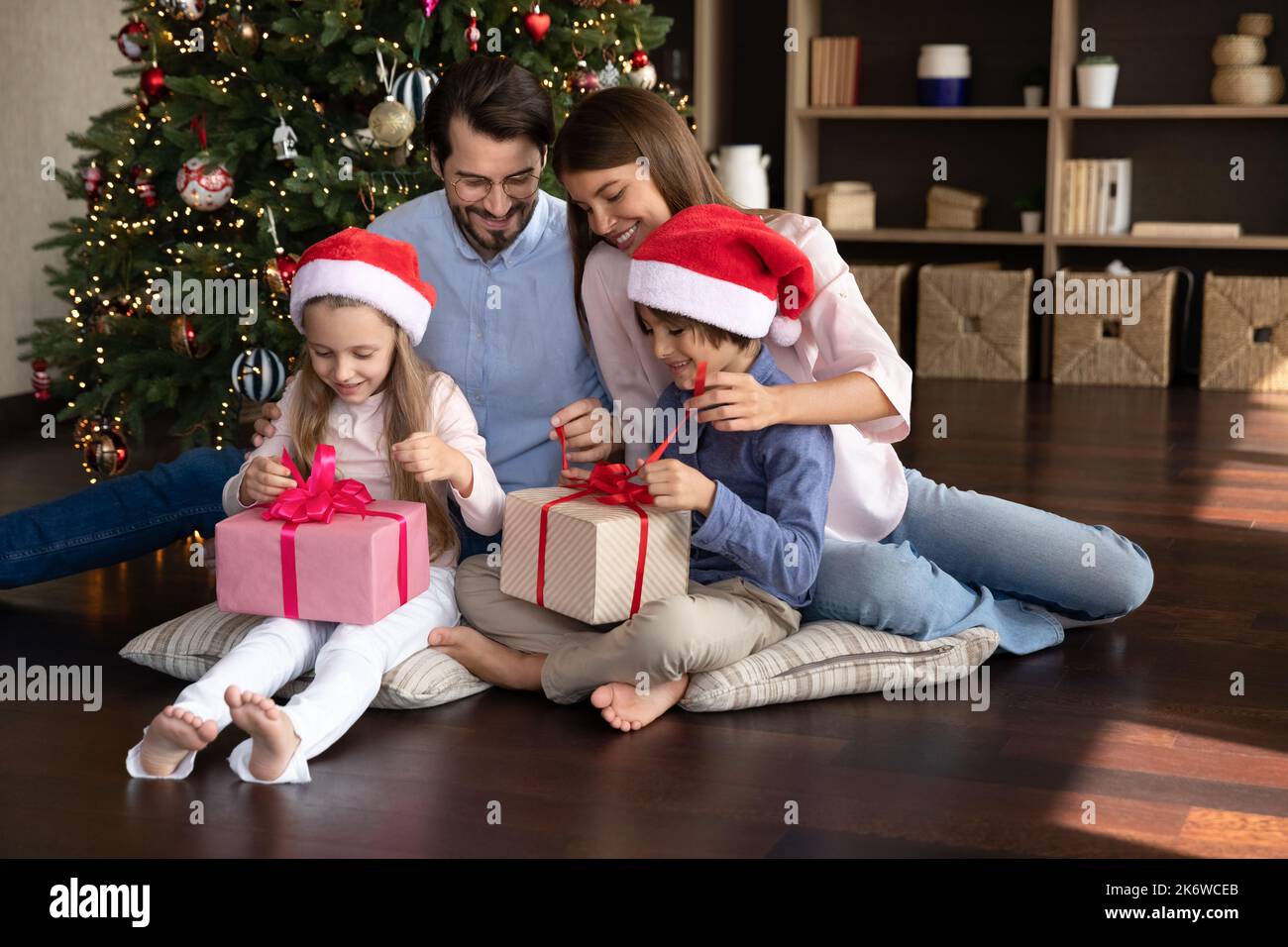 Happy millennial mom and dad giving Christmas gifts to kids Stock Photo ...