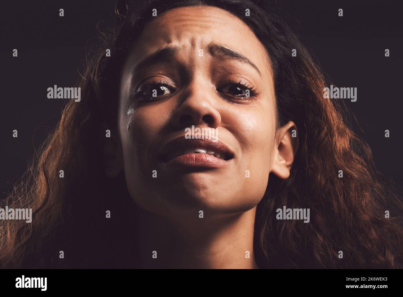 Self-esteem is as important. a young woman crying against a black ...