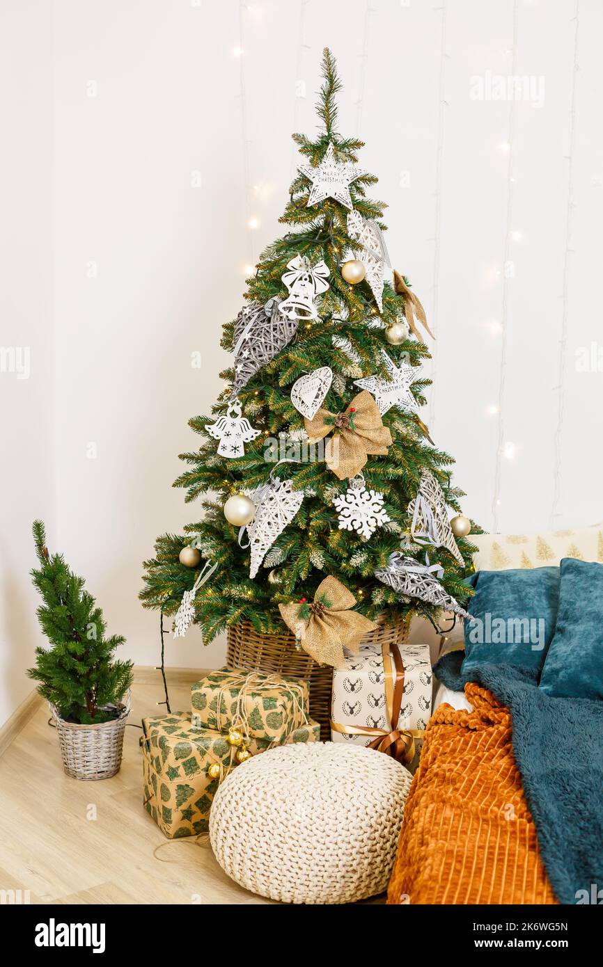 A cozy room decorated with garlands and Christmas trees. White pillow ...